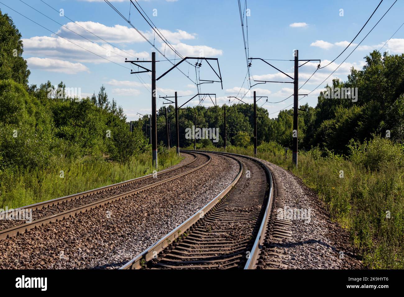 Turning railway tracks in a forest area, electric train Stock Photo - Alamy