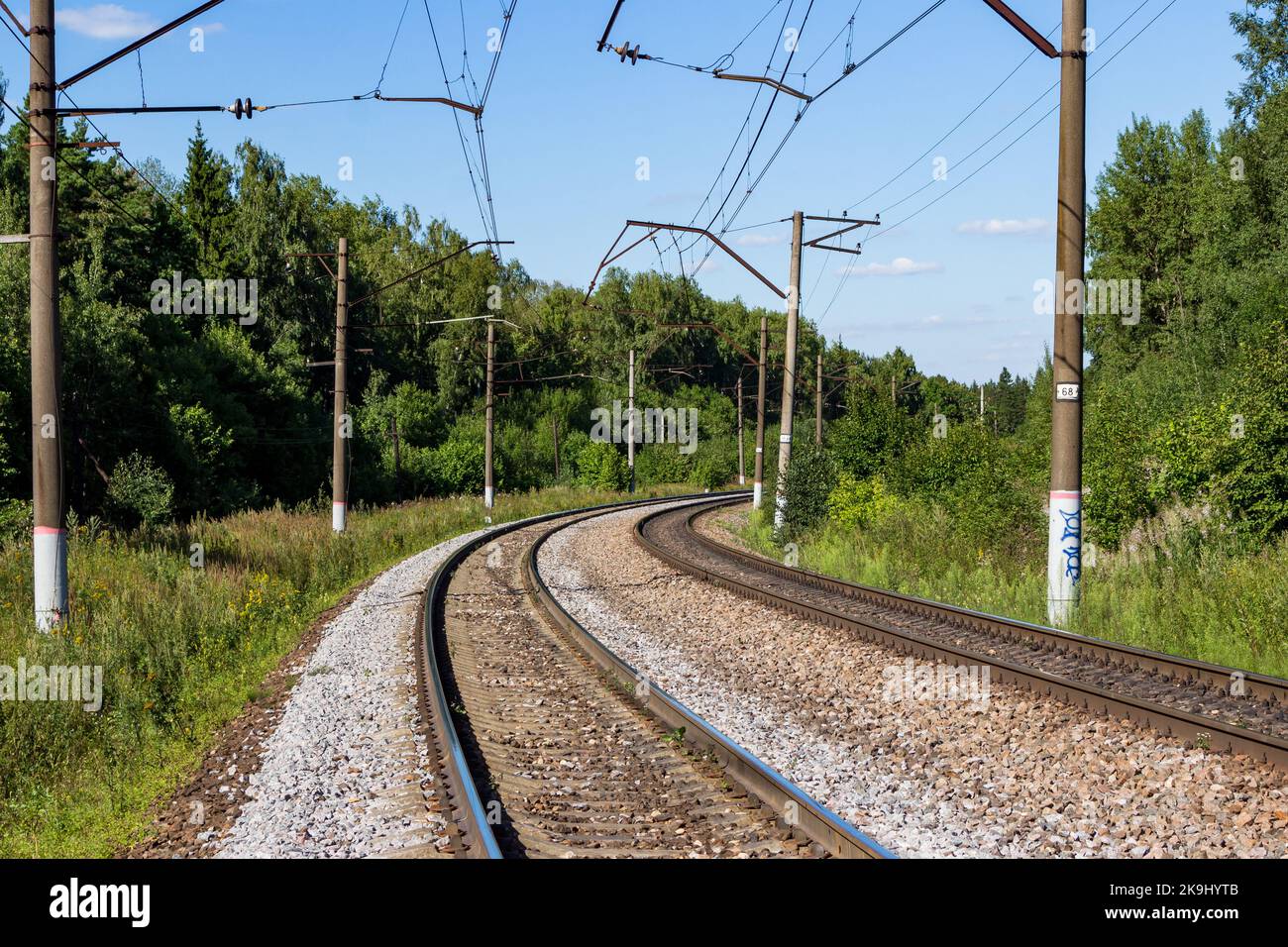Turning railway tracks in a forest area, electric train Stock Photo - Alamy