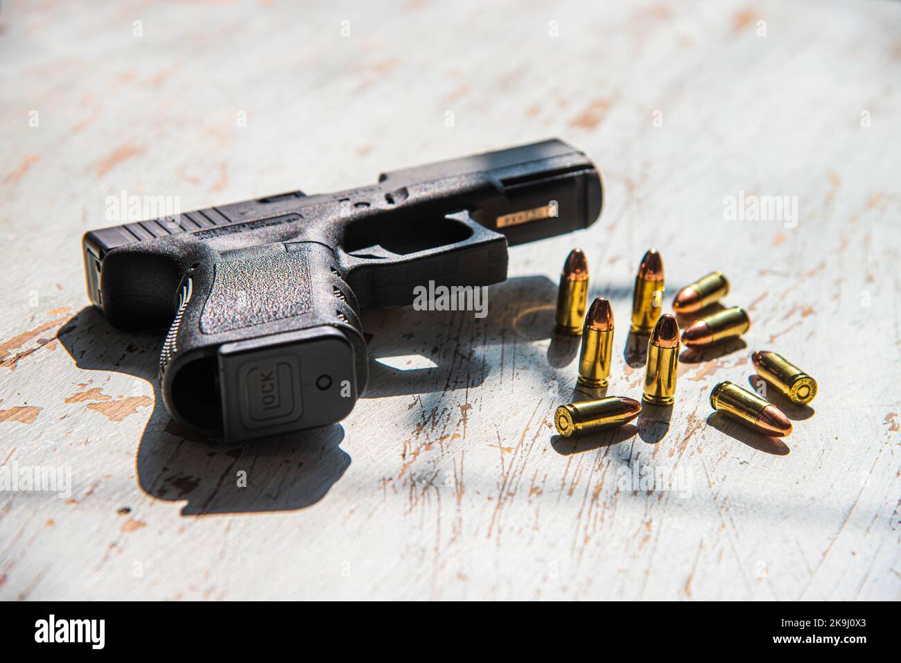 A Glock 19 pistol, manufactured in Austria, lies on a table along with ...
