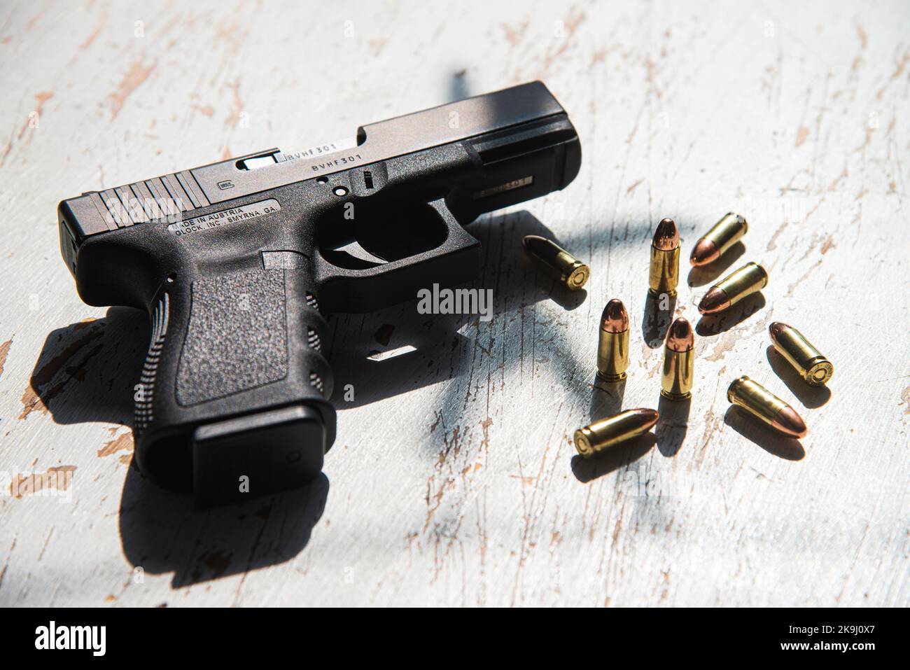 A Glock 19 pistol, manufactured in Austria, lies on a table along with ...