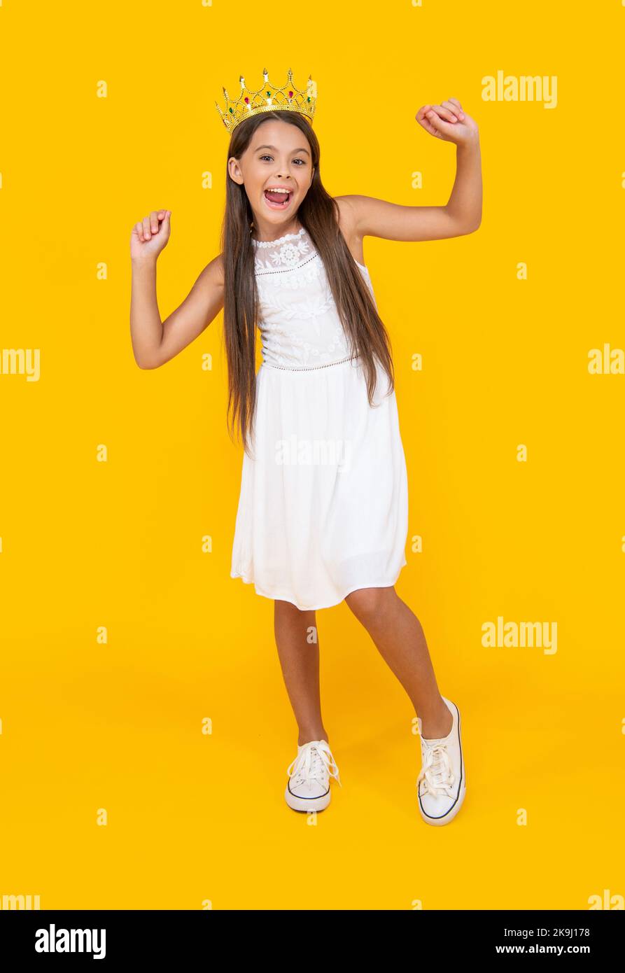 happy teen kid in crown on yellow background Stock Photo - Alamy