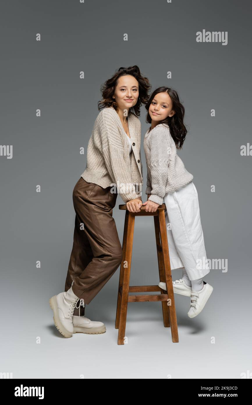 full length of mother and daughter in trendy autumn outfit posing near ...