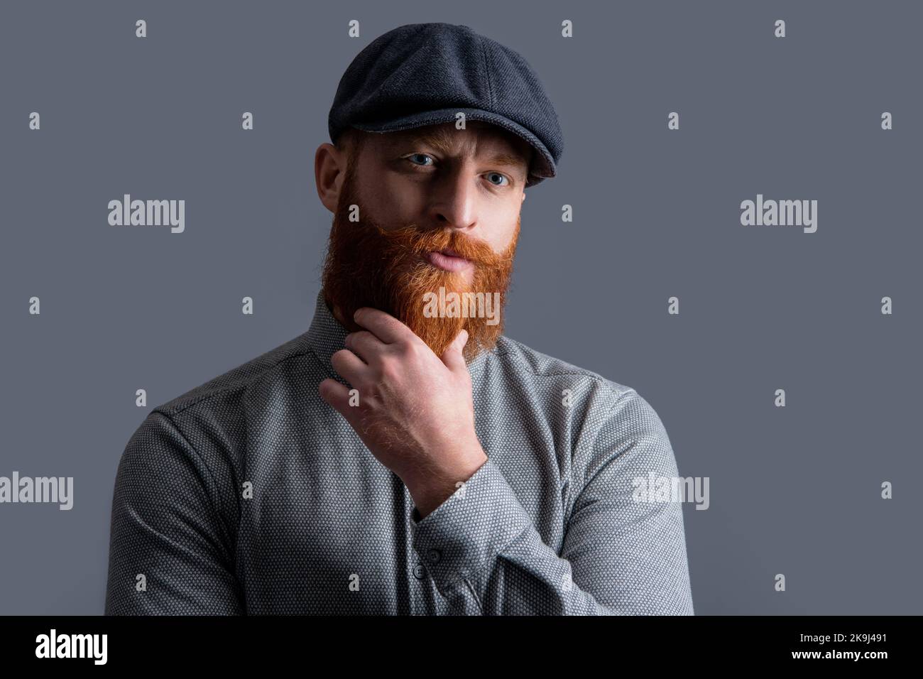 Portrait of Irish guy. Serious guy stroking red beard. Bearded guy with ...