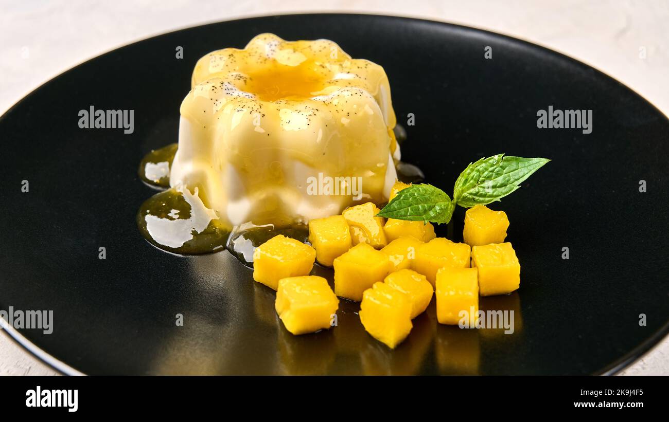Close up panna cotta homemade with natural vanilla pod, mango syrup and ...
