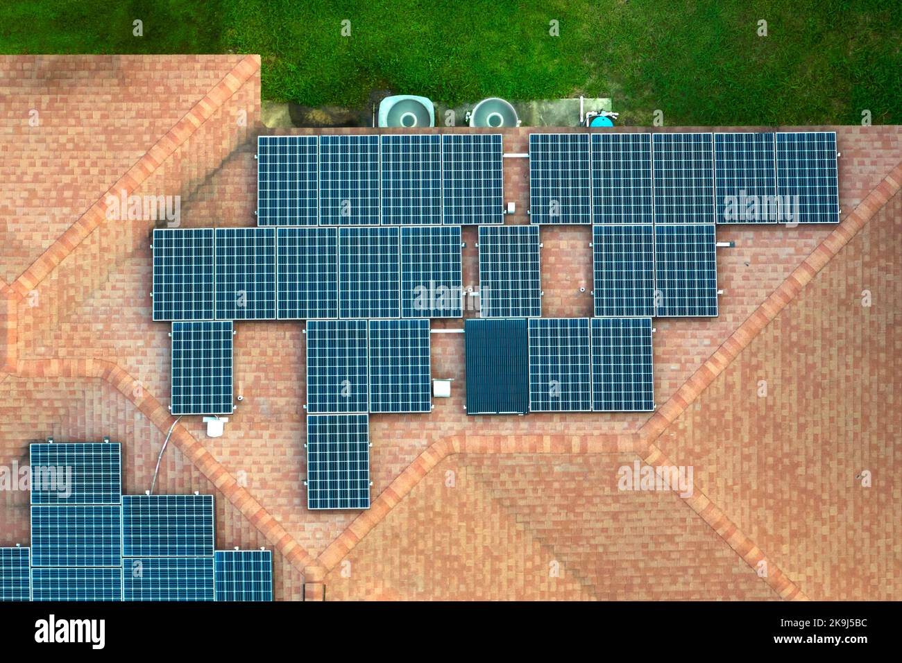 Aerial view of regular american home roof with blue solar photovoltaic ...