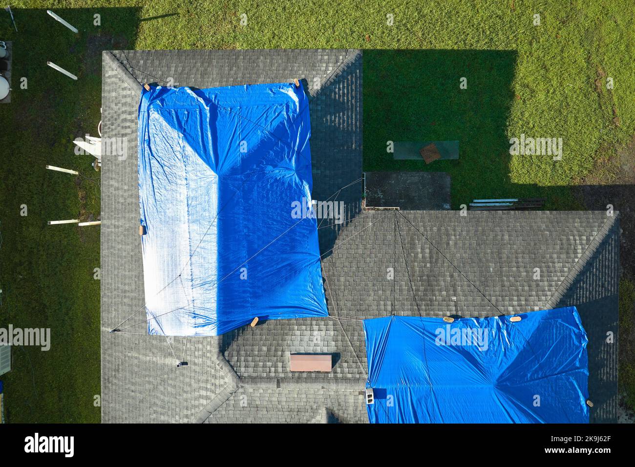 Top view of leaking house roof covered with protective tarp sheets ...