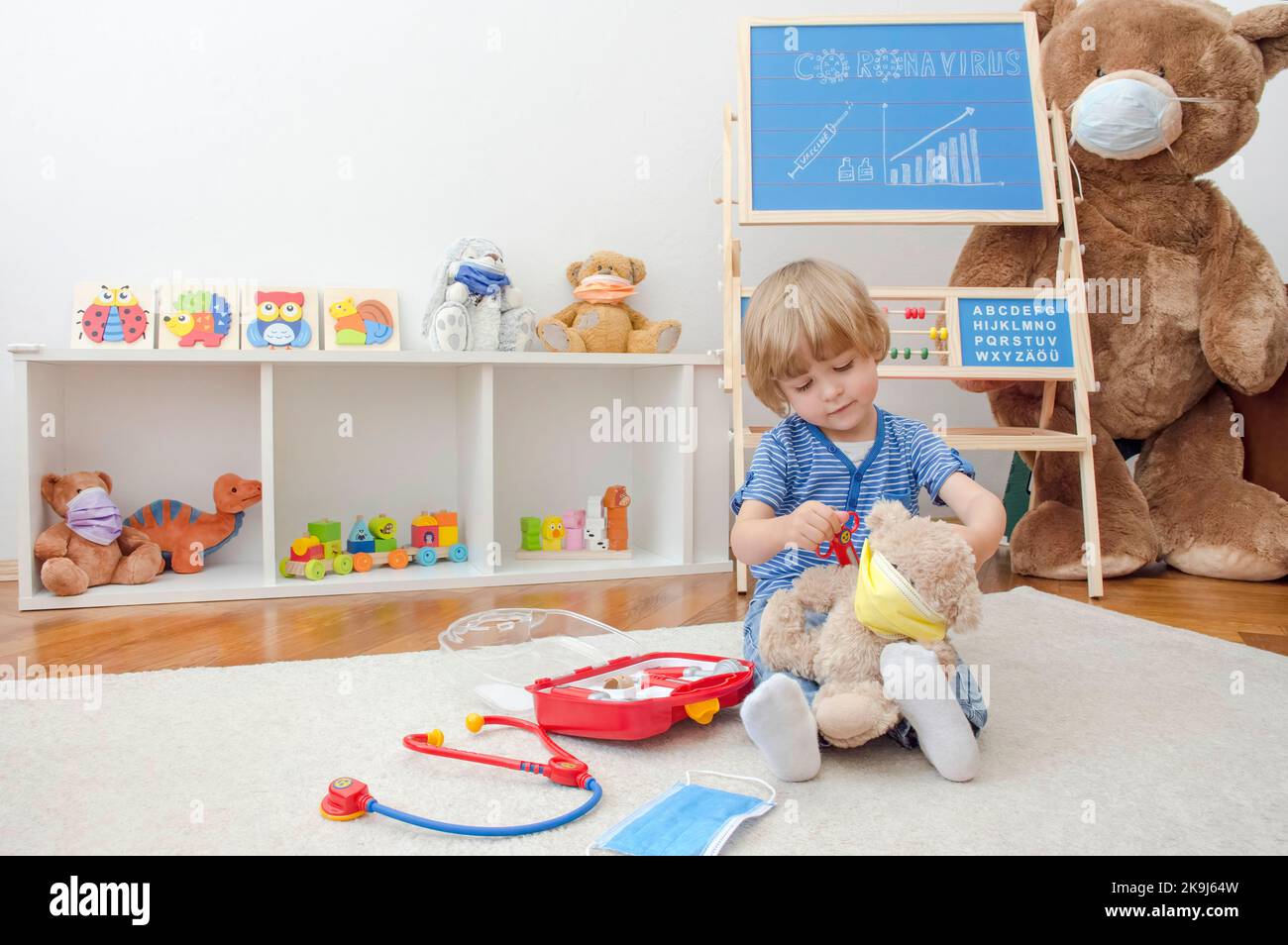 Cute child boy in home quarantine playing doctor with toys wearing ...