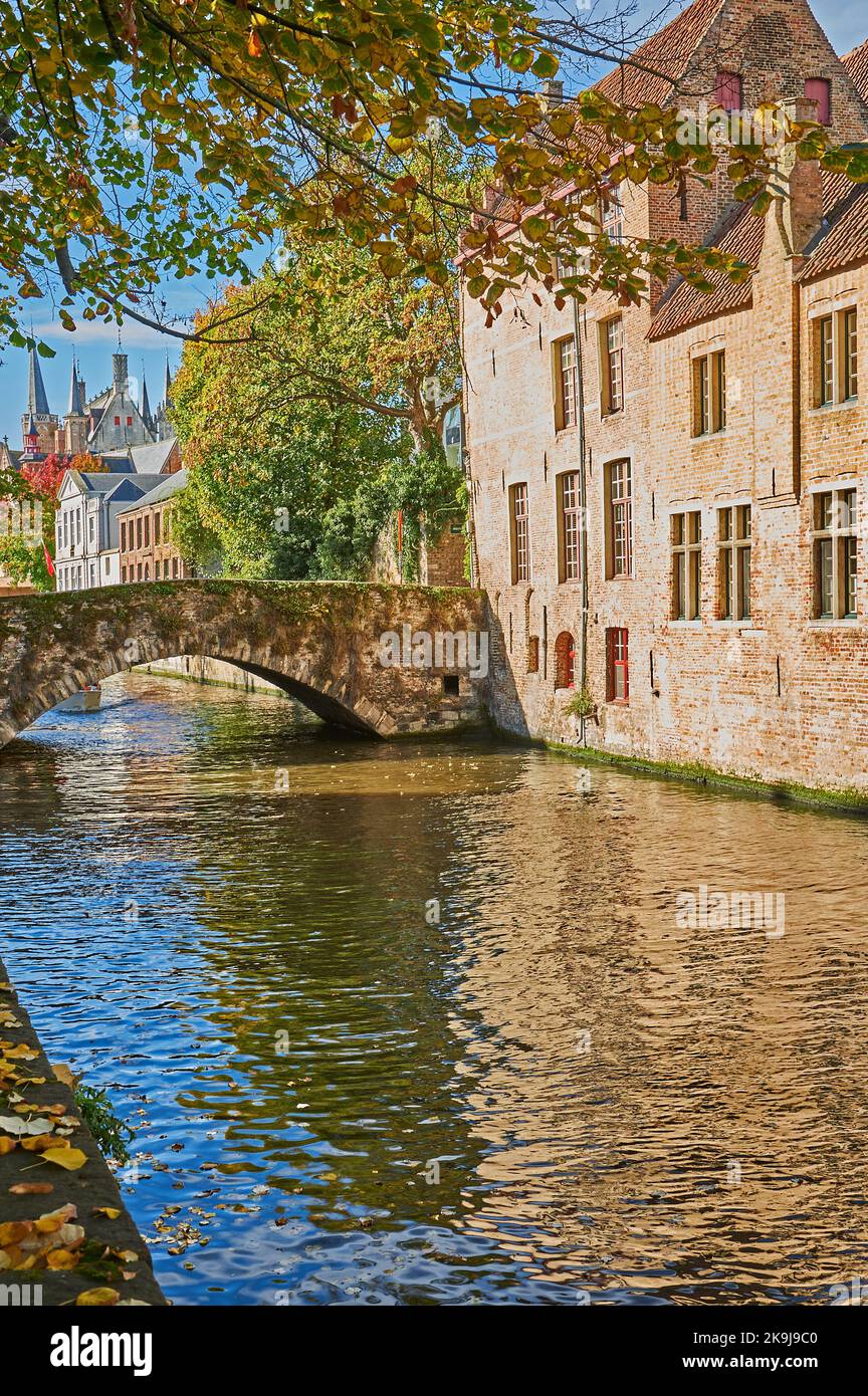 Houses line Groenerei canal in Bruges, Belgium with autumn trees under ...