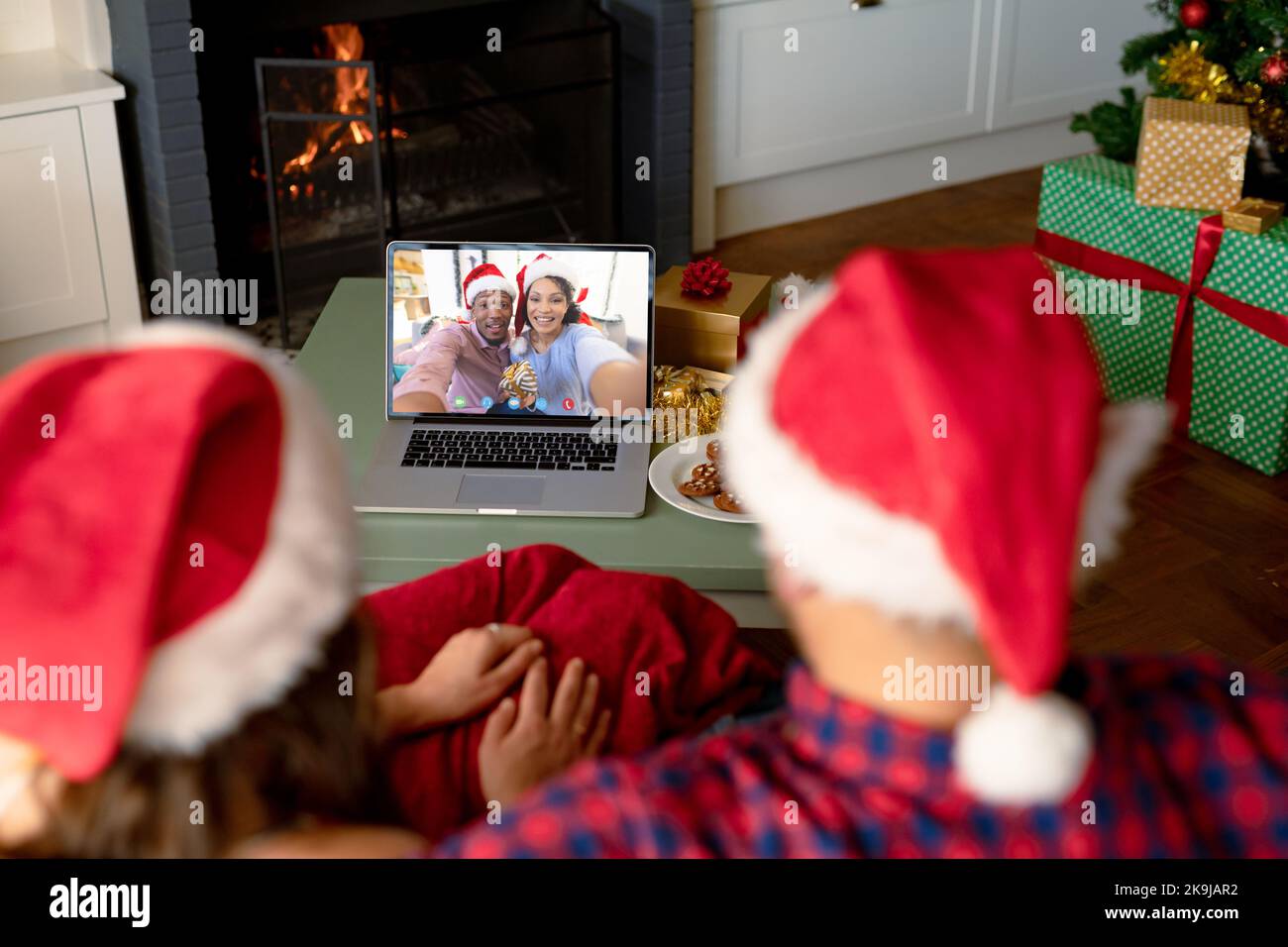 Caucasian couple having christmas video call with african american ...