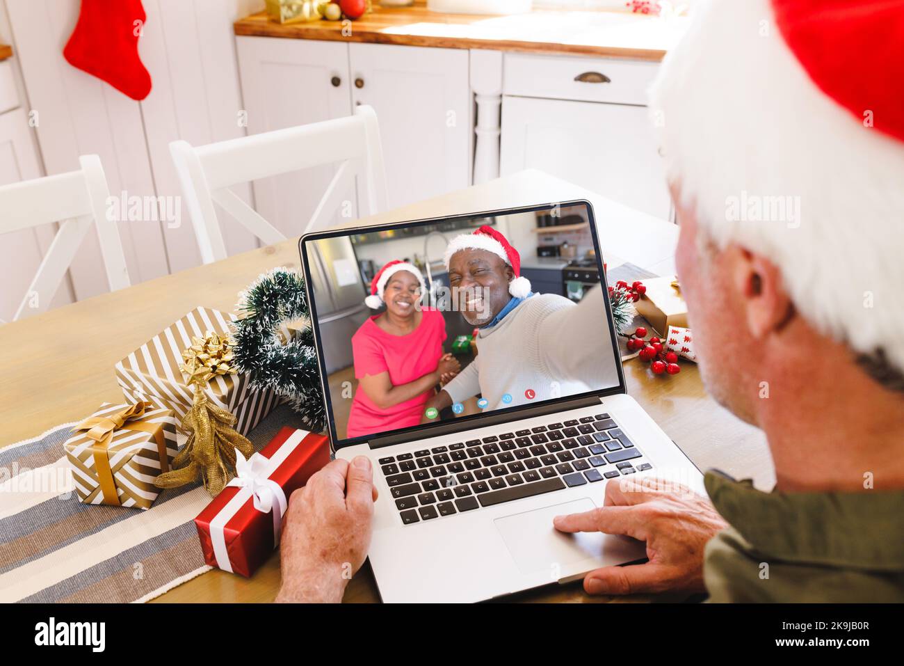 Senior caucasian man having christmas video call with senior african ...