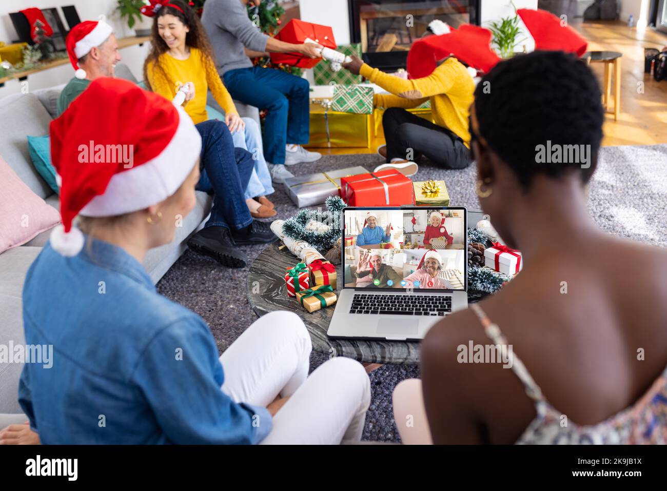 Diverse group of friends having christmas video call with diverse ...
