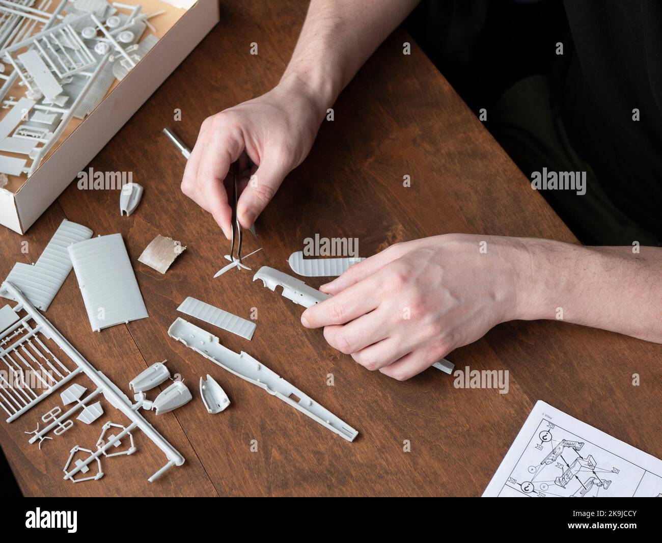 Person is assembling several small pieces to make the final aircraft ...