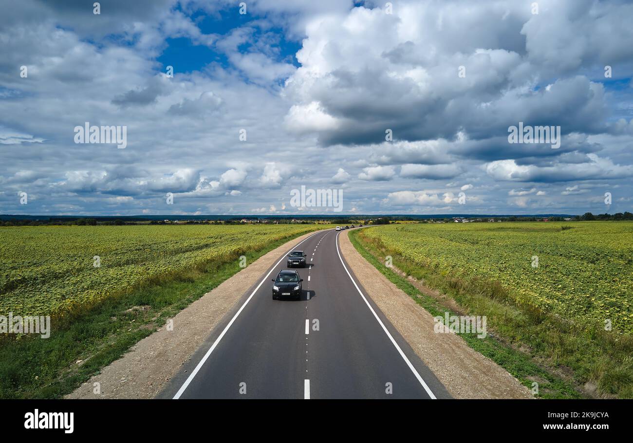 Aerial view of intercity road between green agricultural fields with ...