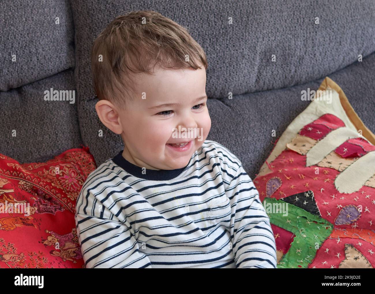 cute boy laughing on the couch Stock Photo - Alamy
