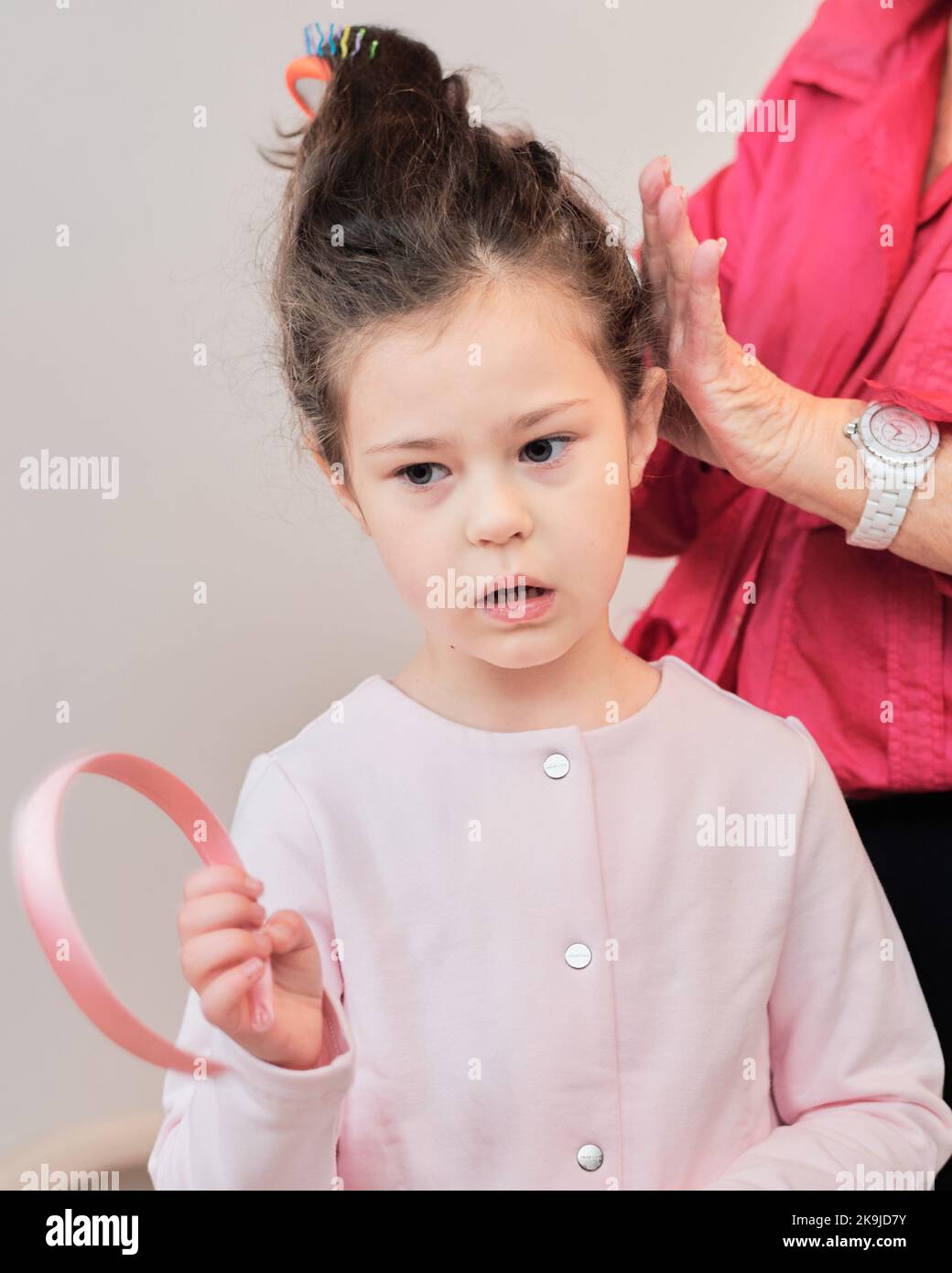 expressive little girl being dressed by grandmother Stock Photo - Alamy