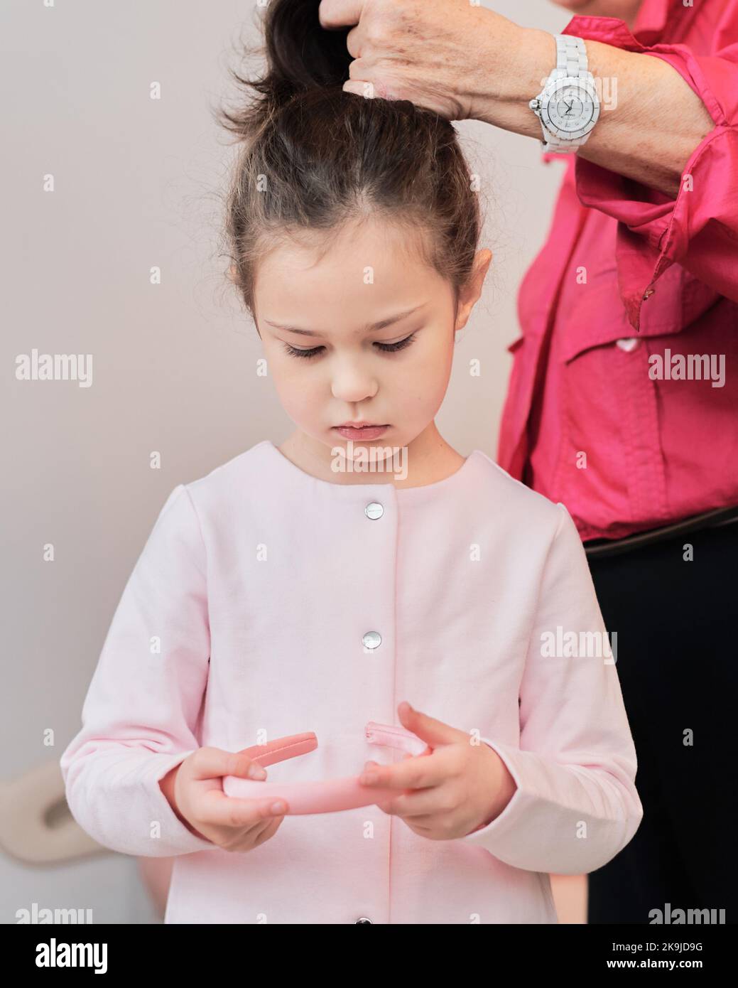 expressive little girl being dressed by grandmother Stock Photo - Alamy
