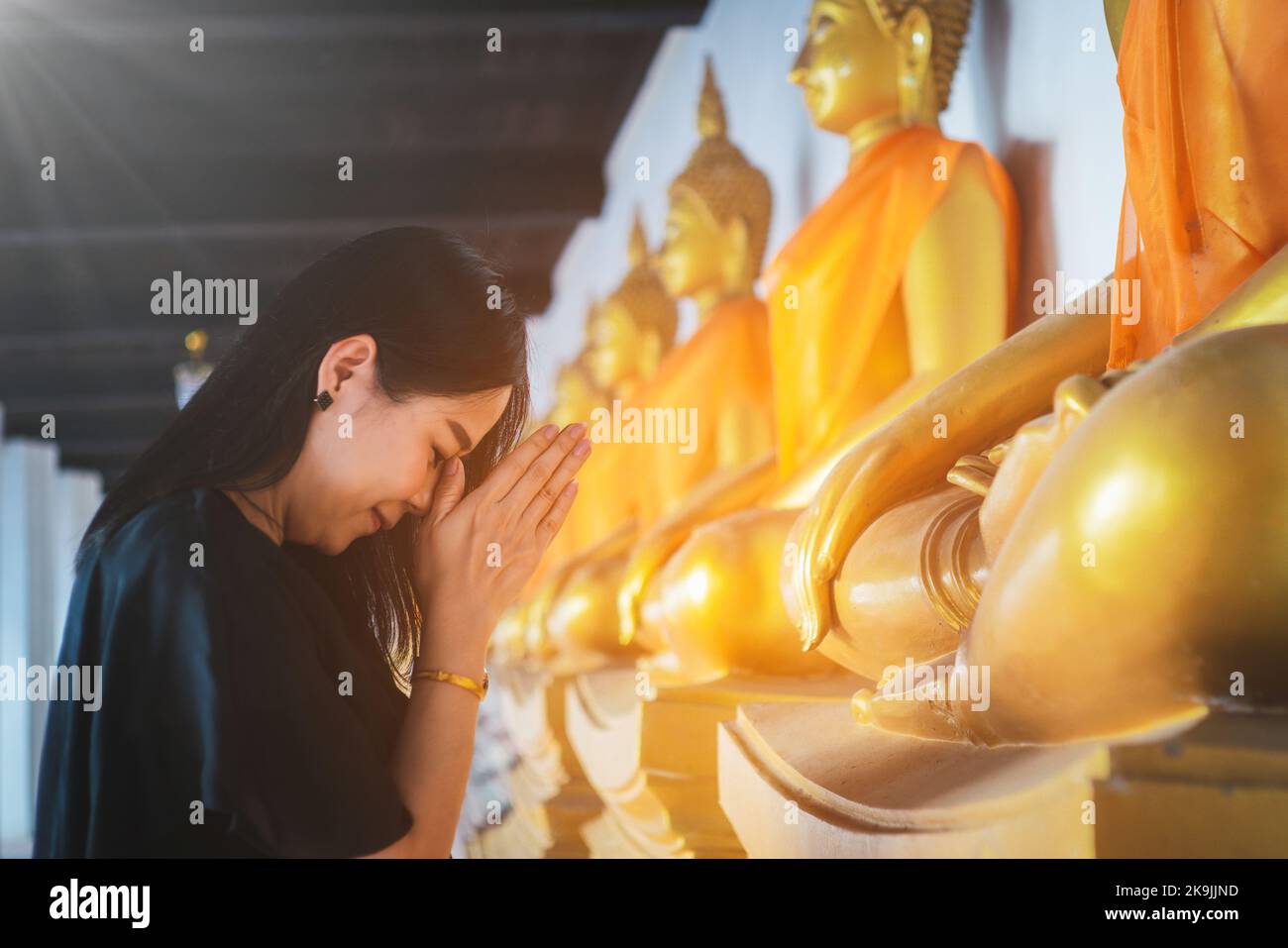 Beautiful asian woman pays homage to the Buddha statue with respect and ...