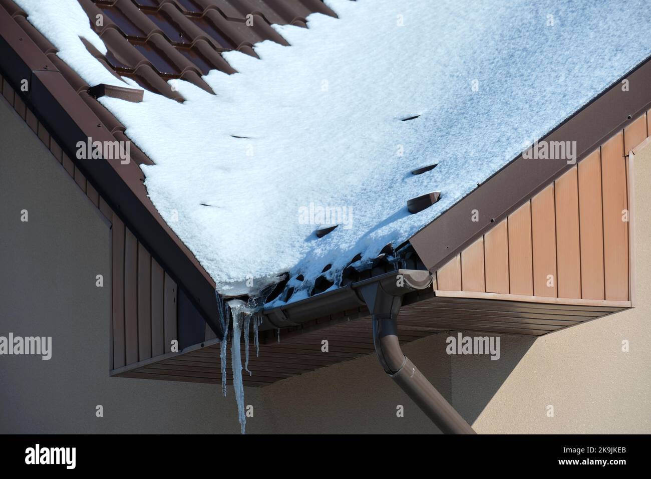 Closeup of house roof top covered with snow in cold winter. Tiled ...