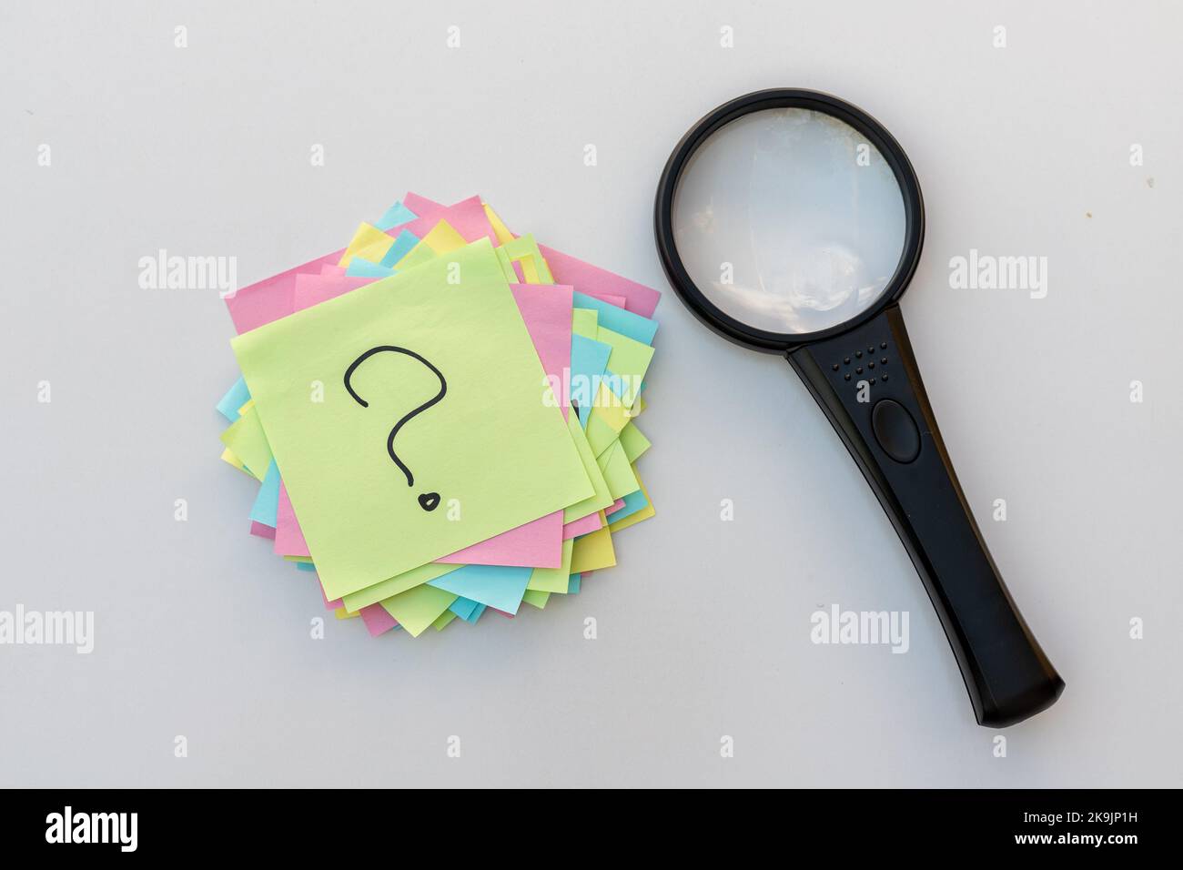 The question mark sign hand written on a sticky note along a searching ...