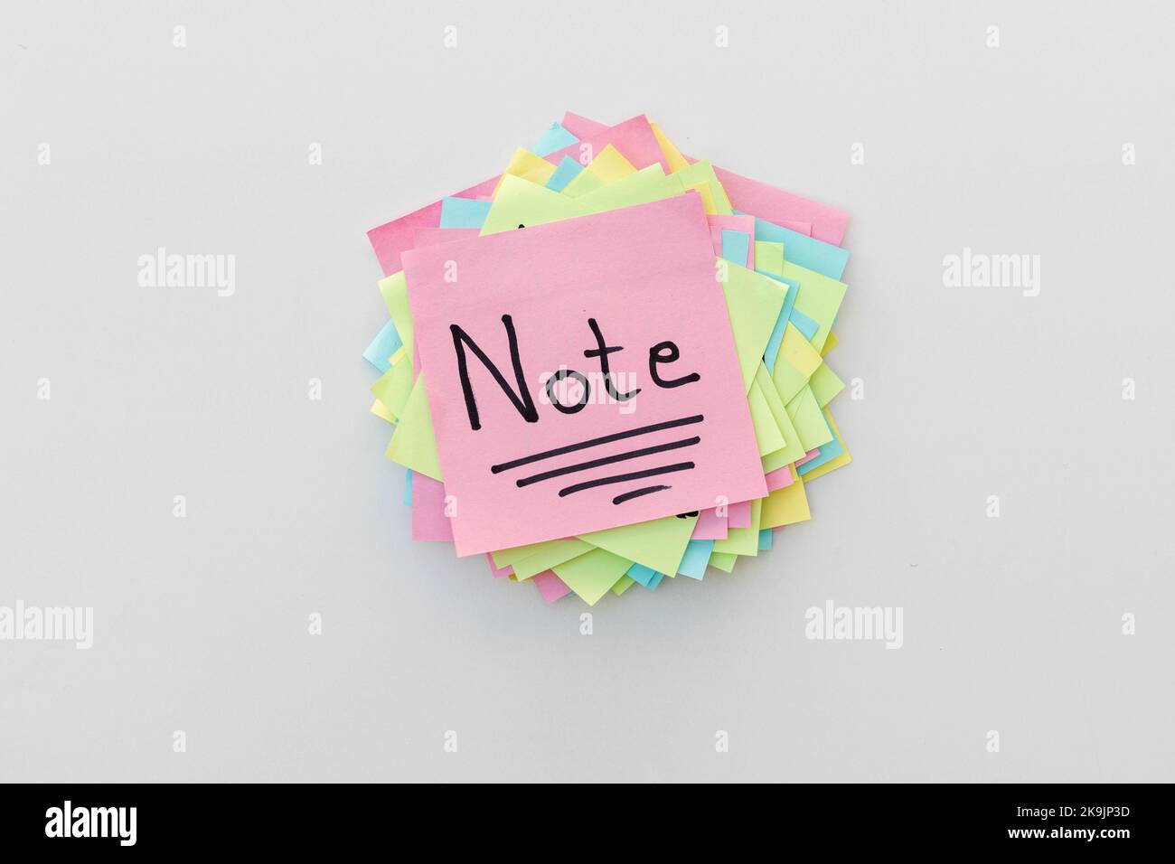 Handwritten word Note on a sticky note with a white isolated background ...