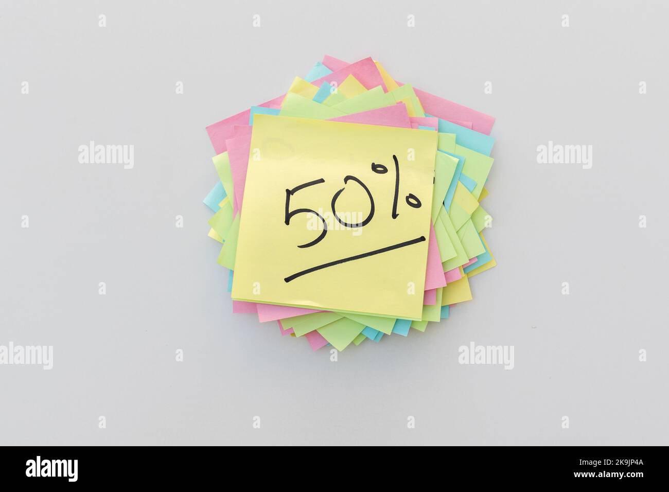 Hand written 50% on a yellow sticky note on white isolated background ...