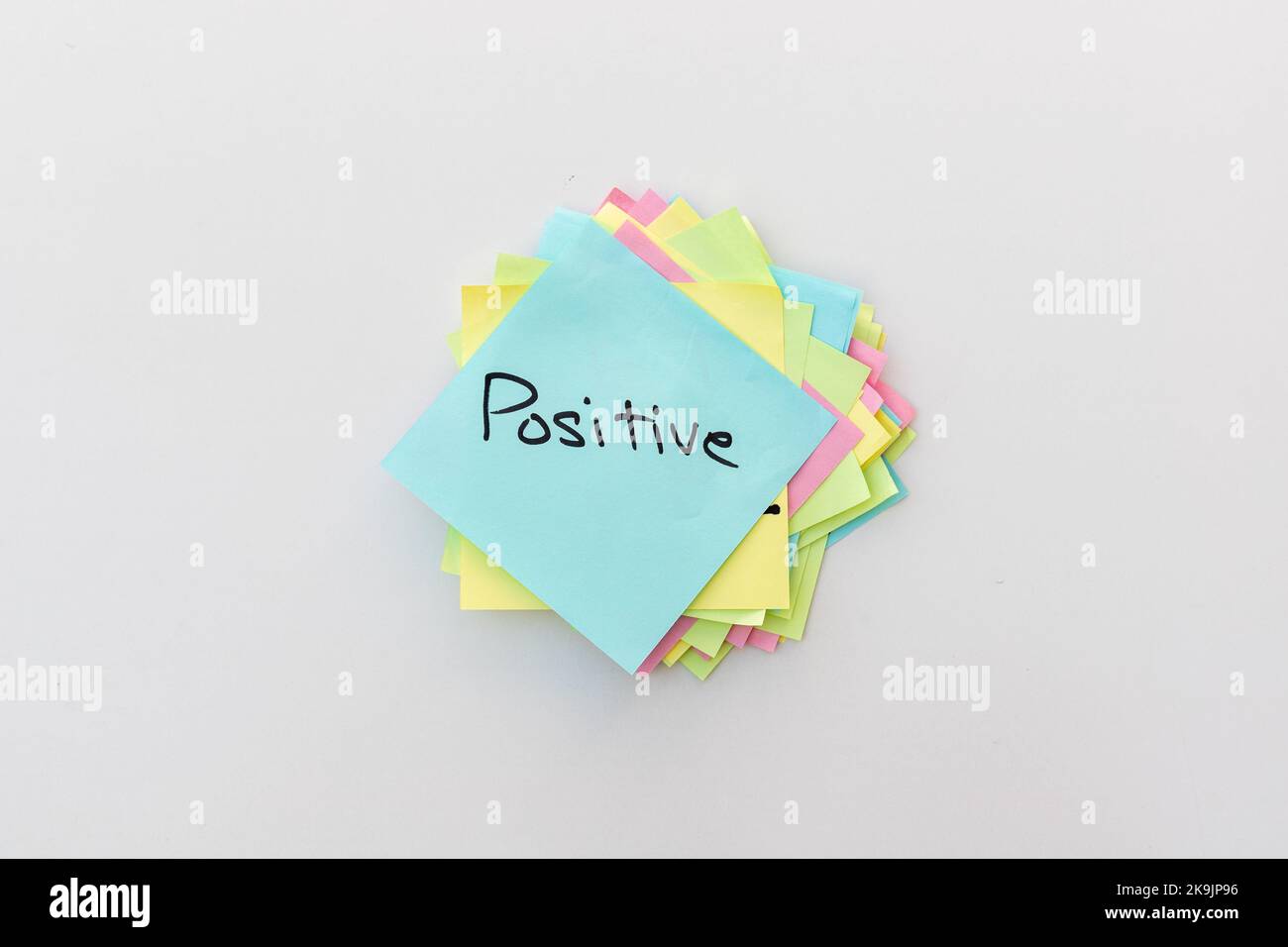Positive word hand written on a sticky note Stock Photo - Alamy
