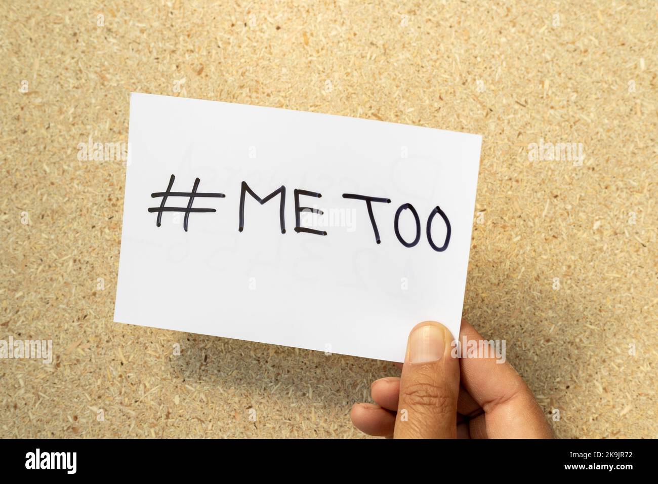 Holding a white card with word Me Too hash tag. Stop harassment at work ...