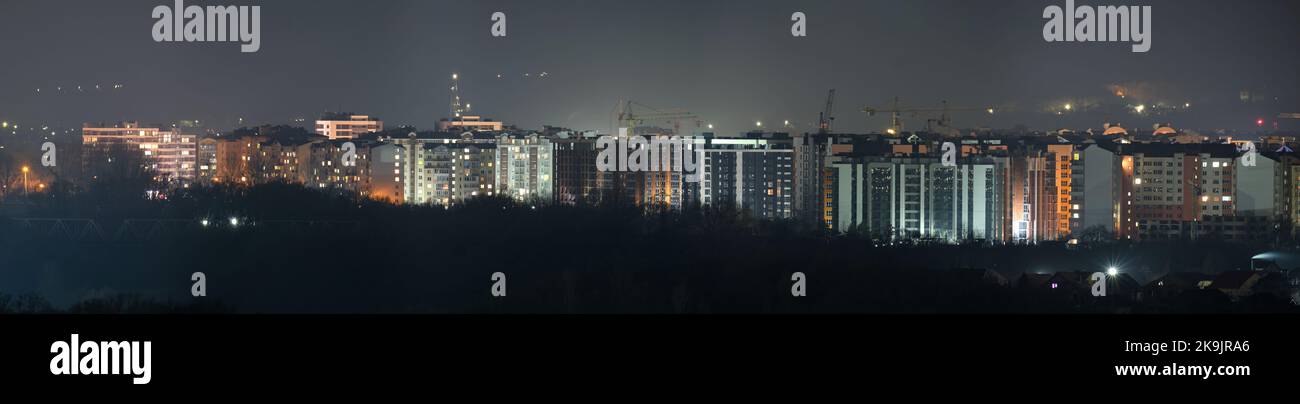 Dark silhouette of tower cranes at high residential apartment buildings ...