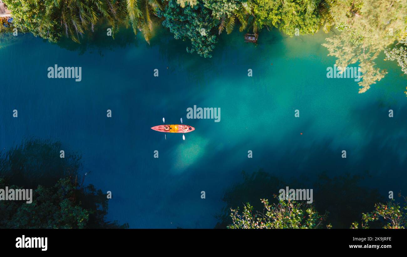 A couple of men and women are Kayaking in the rainforest of Koh Chang ...