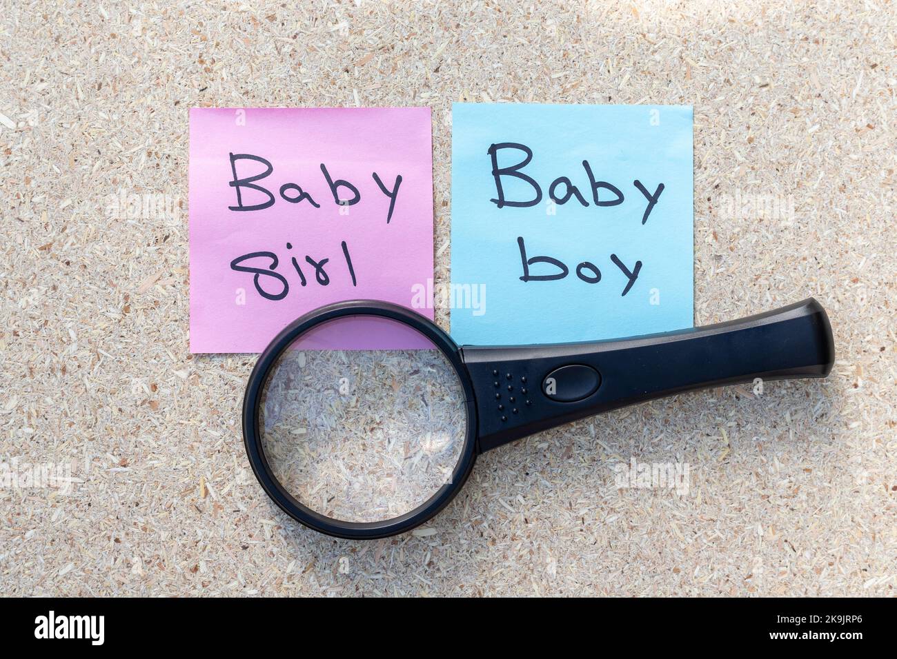 Girl or boy gender reveal hand written on a pink and blue note paper ...