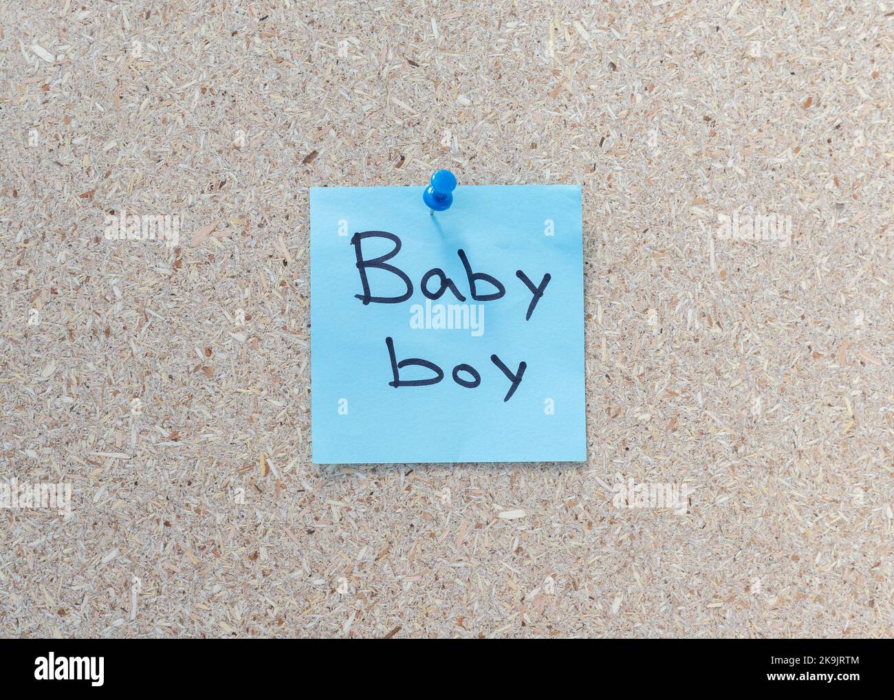 Surprise gender reveals hand written message on a a blue sticky note on ...