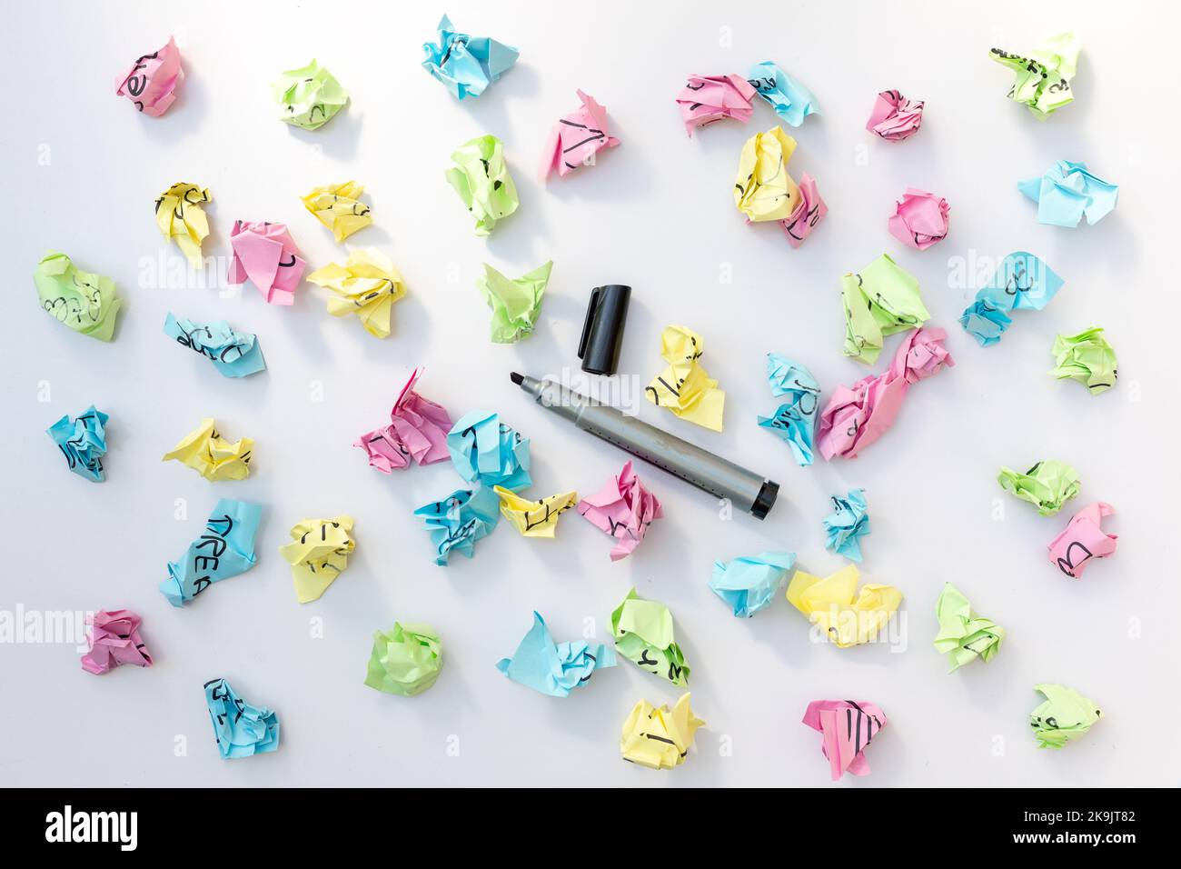 Empty note papers with a black marker and crumbled paper on white ...