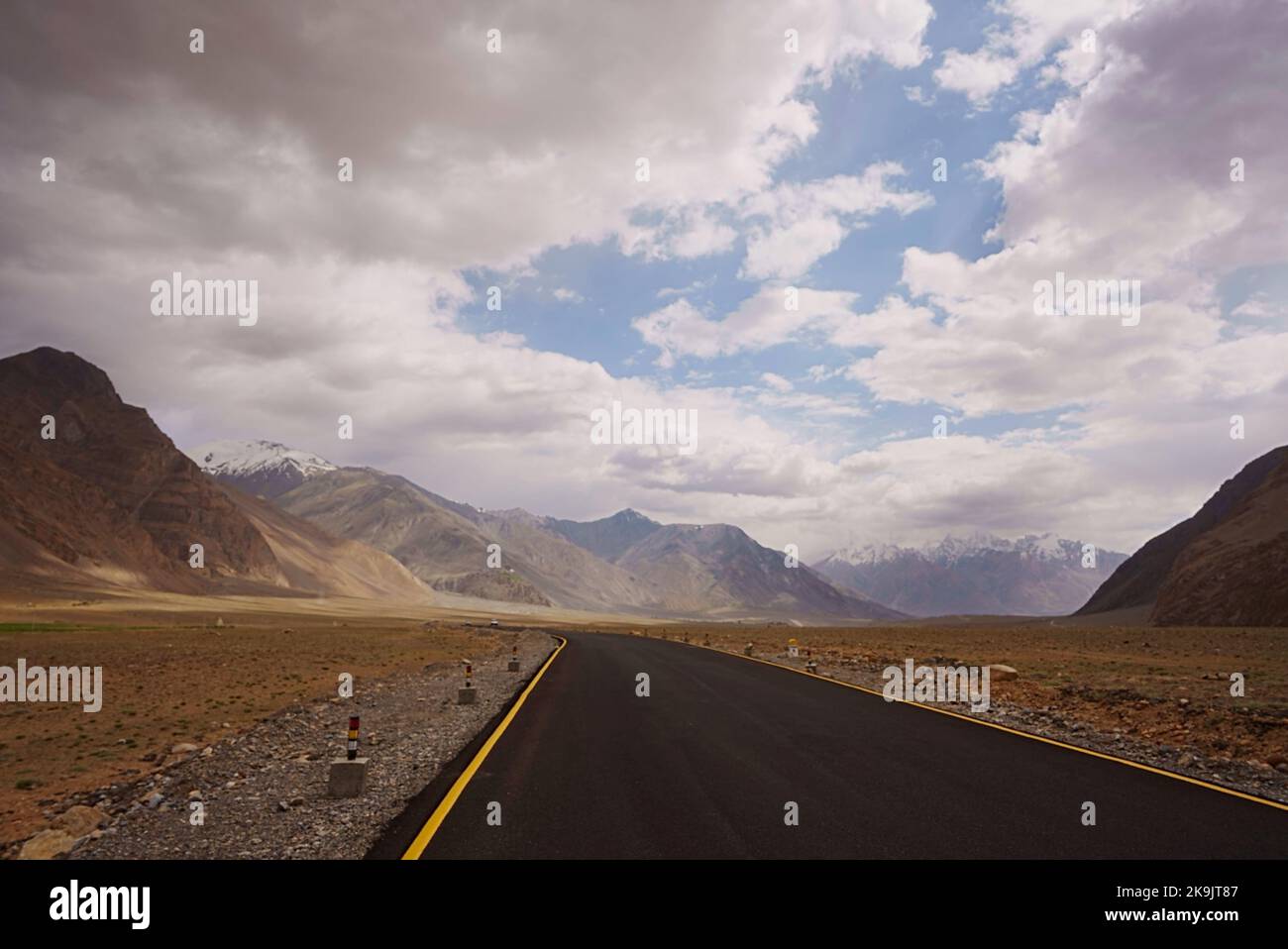 A tarmac road stretches across a wide open plain in the high altitude ...