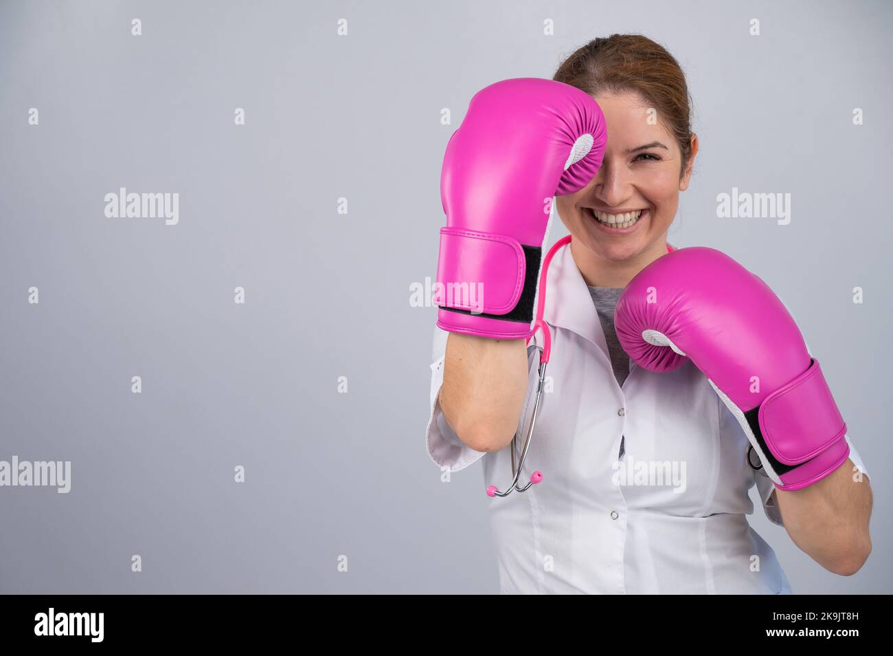 Woman doctor in pink boxing gloves on a white background Stock Photo ...
