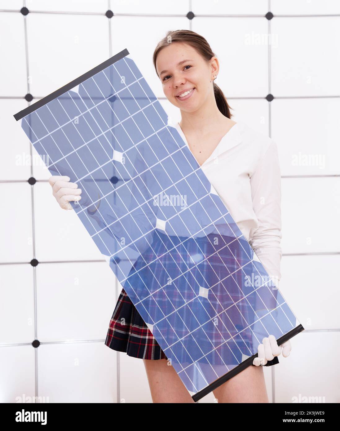 young woman dressed in a short skirt with a transparent solar panel in ...