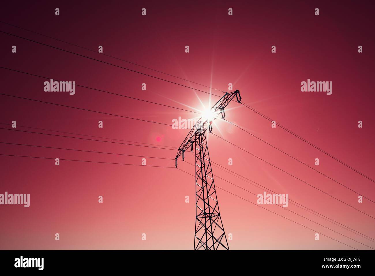 high-voltage power line against the background of a red sky and a ...