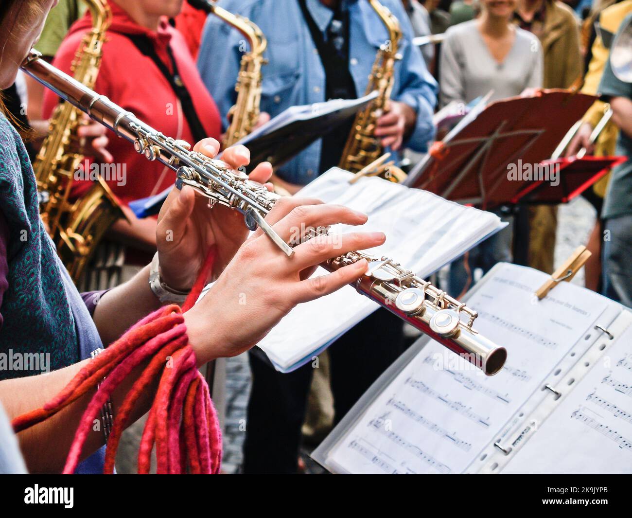 Closeup of flute and hands of flautist in group in street performers ...
