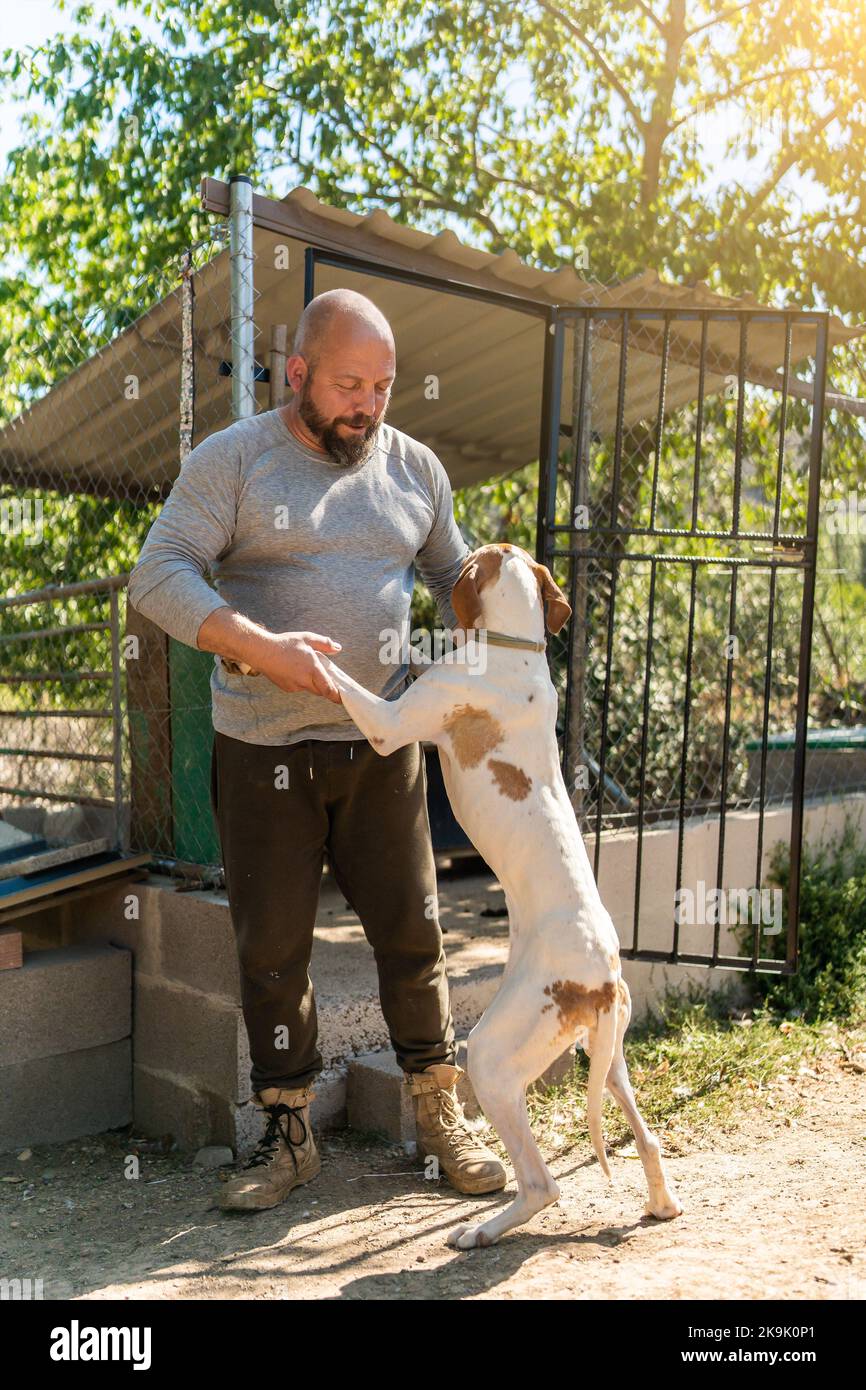 Dog jumping on top of a man petting him Stock Photo - Alamy