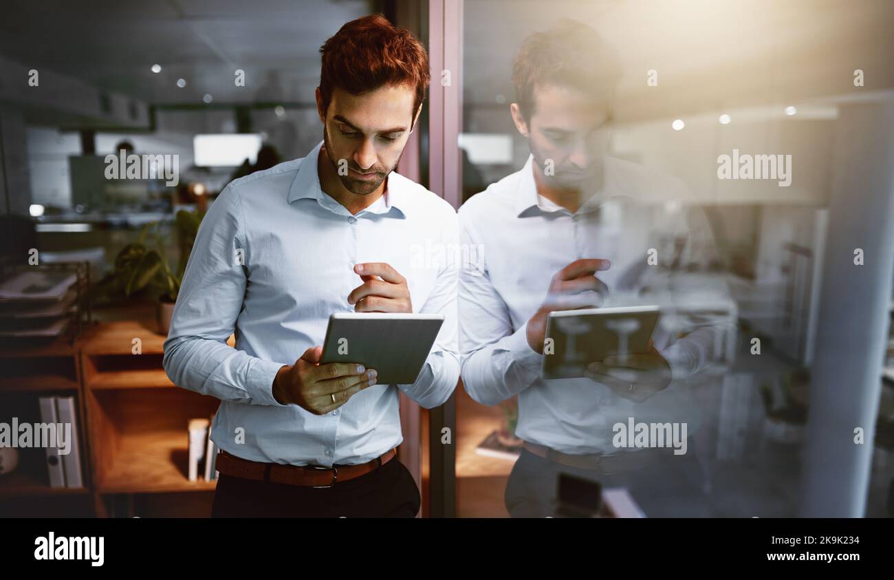Technology helps him sort it all out. a young businessman working late ...