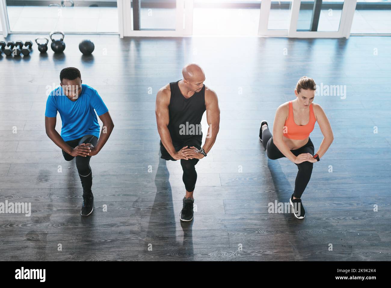 Keep your lunges low and standards high. people working out in the gym ...
