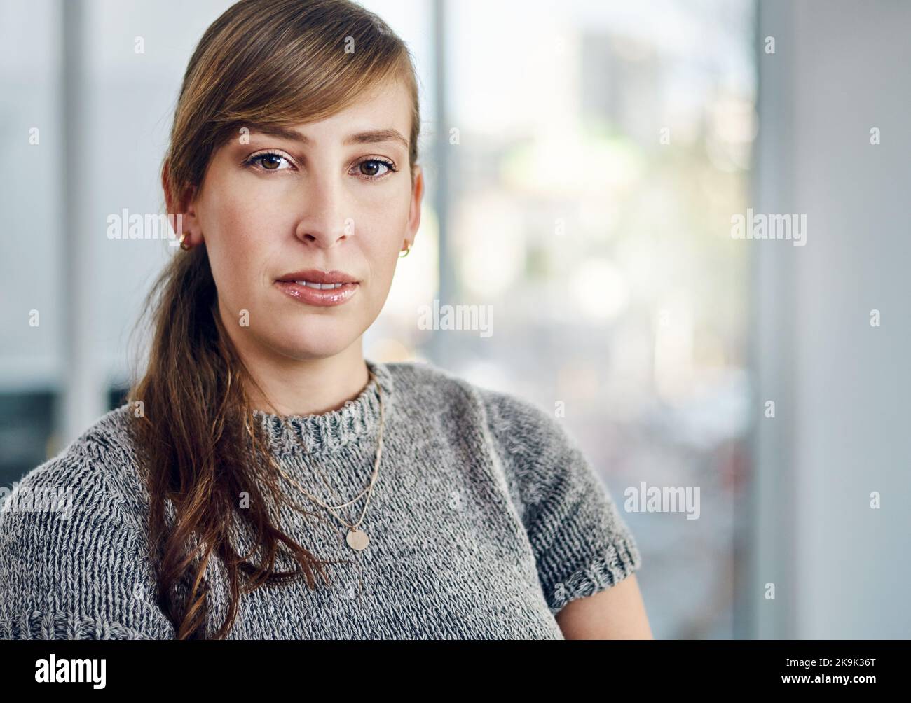 She is ready to make deals. Portrait of a confident young businesswoman standing inside the ...