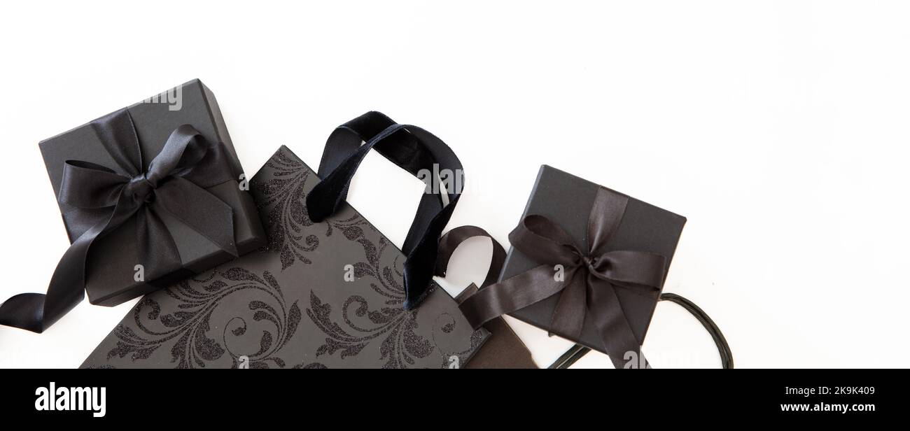 Black Friday sale banner. Shopping paper bag and gift box with curly ...