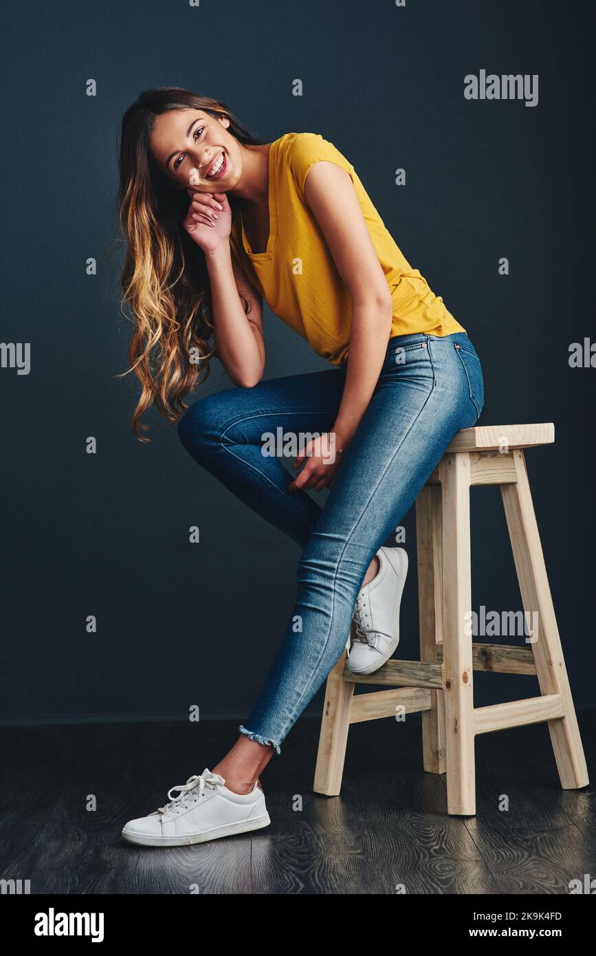 Taking it easy ...Studio shot of an attractive young woman against a ...