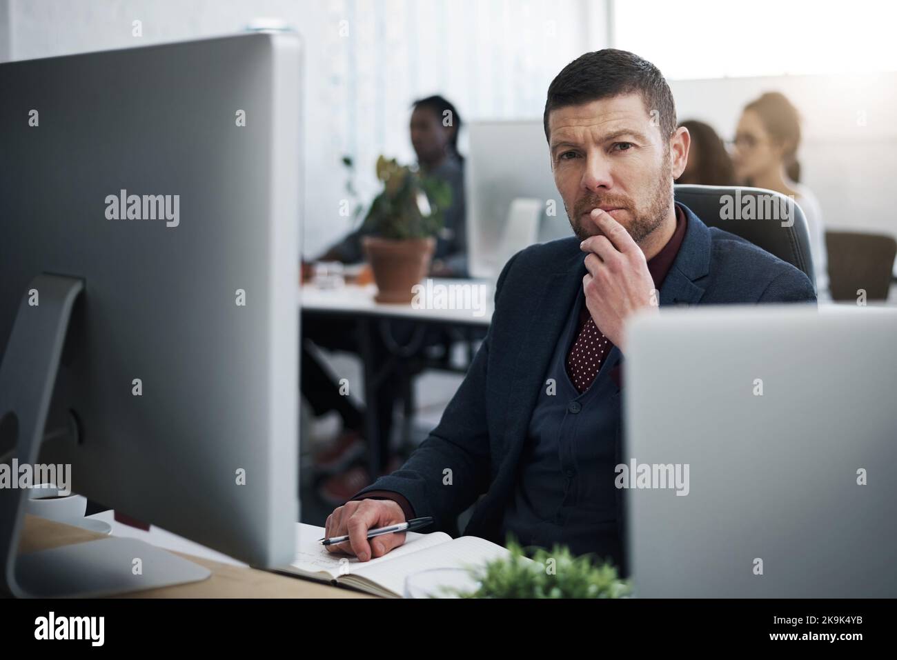 Flexing his mental muscle. a mature businessman using a computer at his ...
