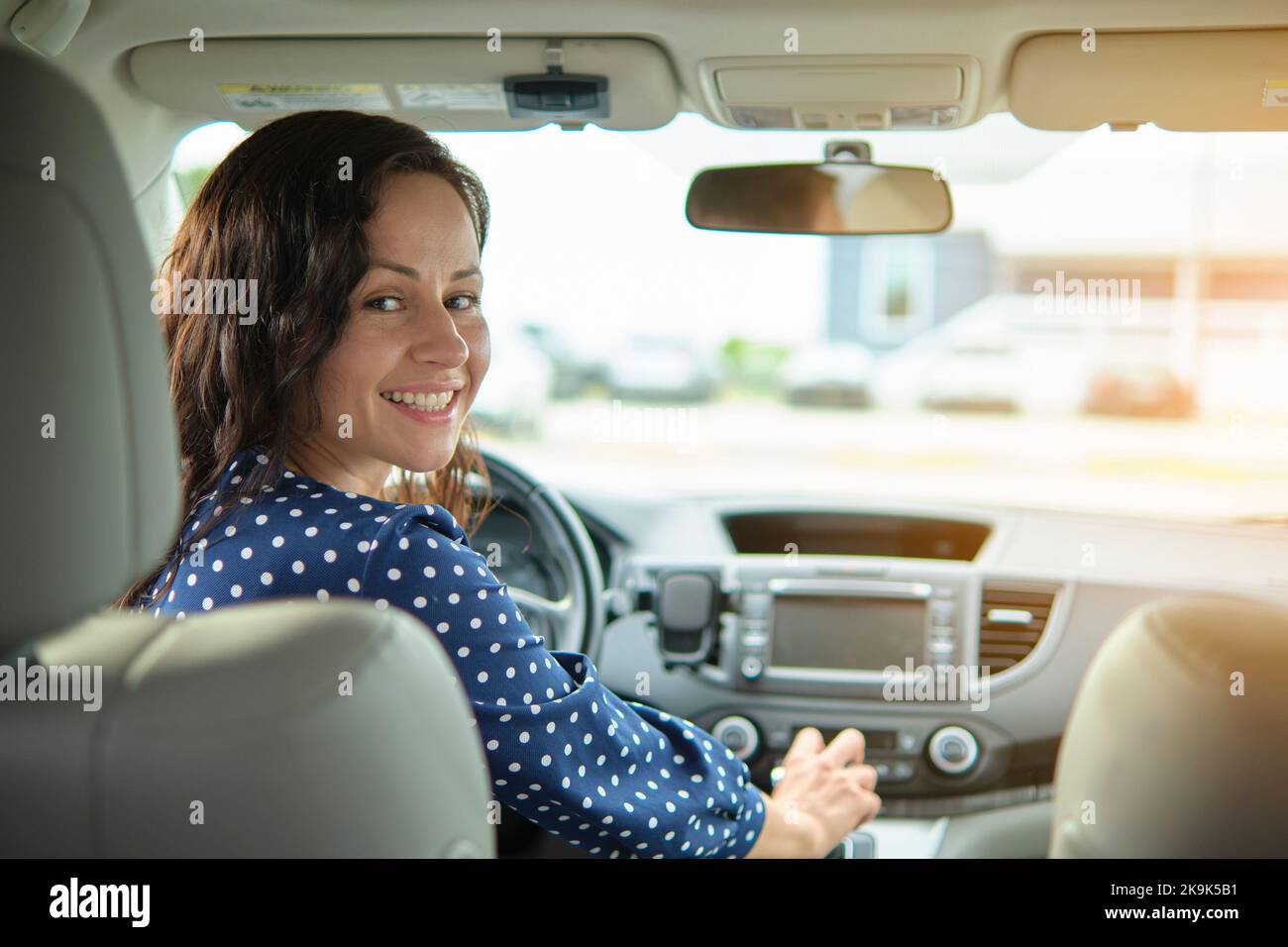Portrait of attractive young woman in casual dress looking over her ...