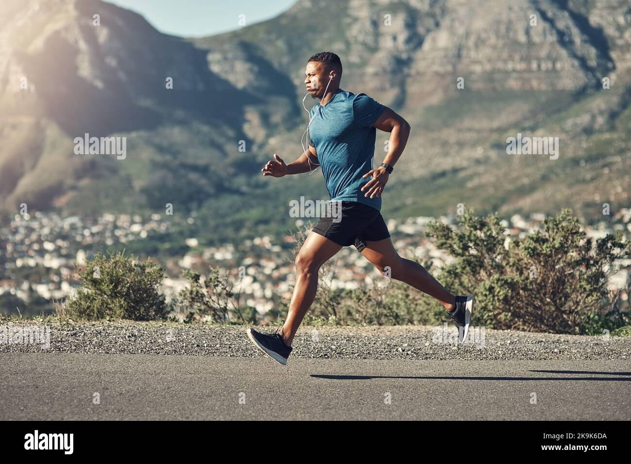 Endure the pain and gain fitness. a young handsome man running outdoors ...