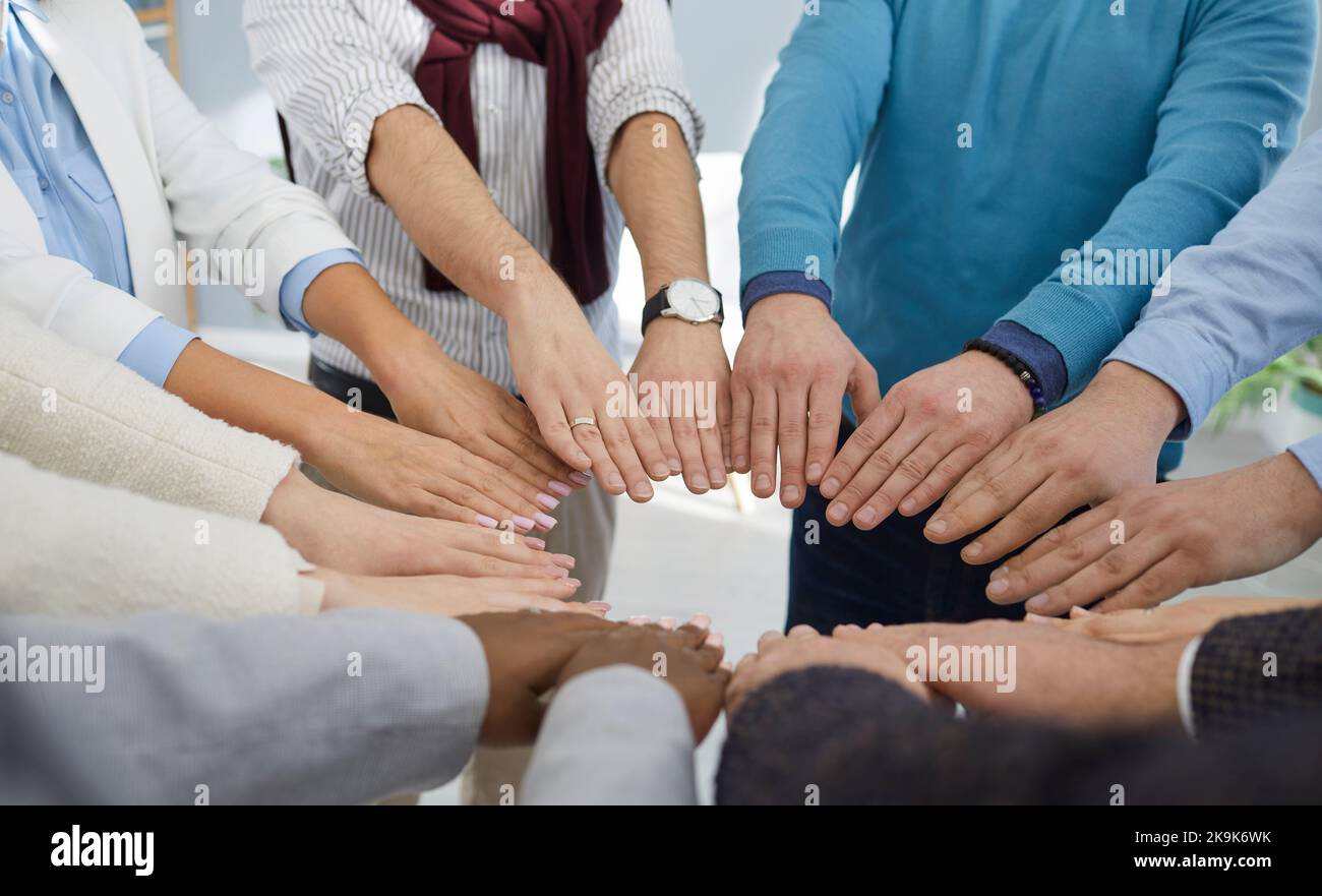 Diverse team of business people join their hands to show concept of ...