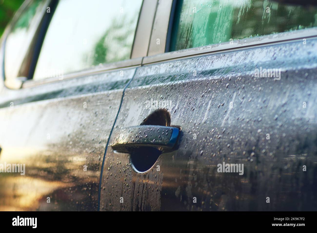 Wet car door at morning light. Close-up of and shallow depht of field ...