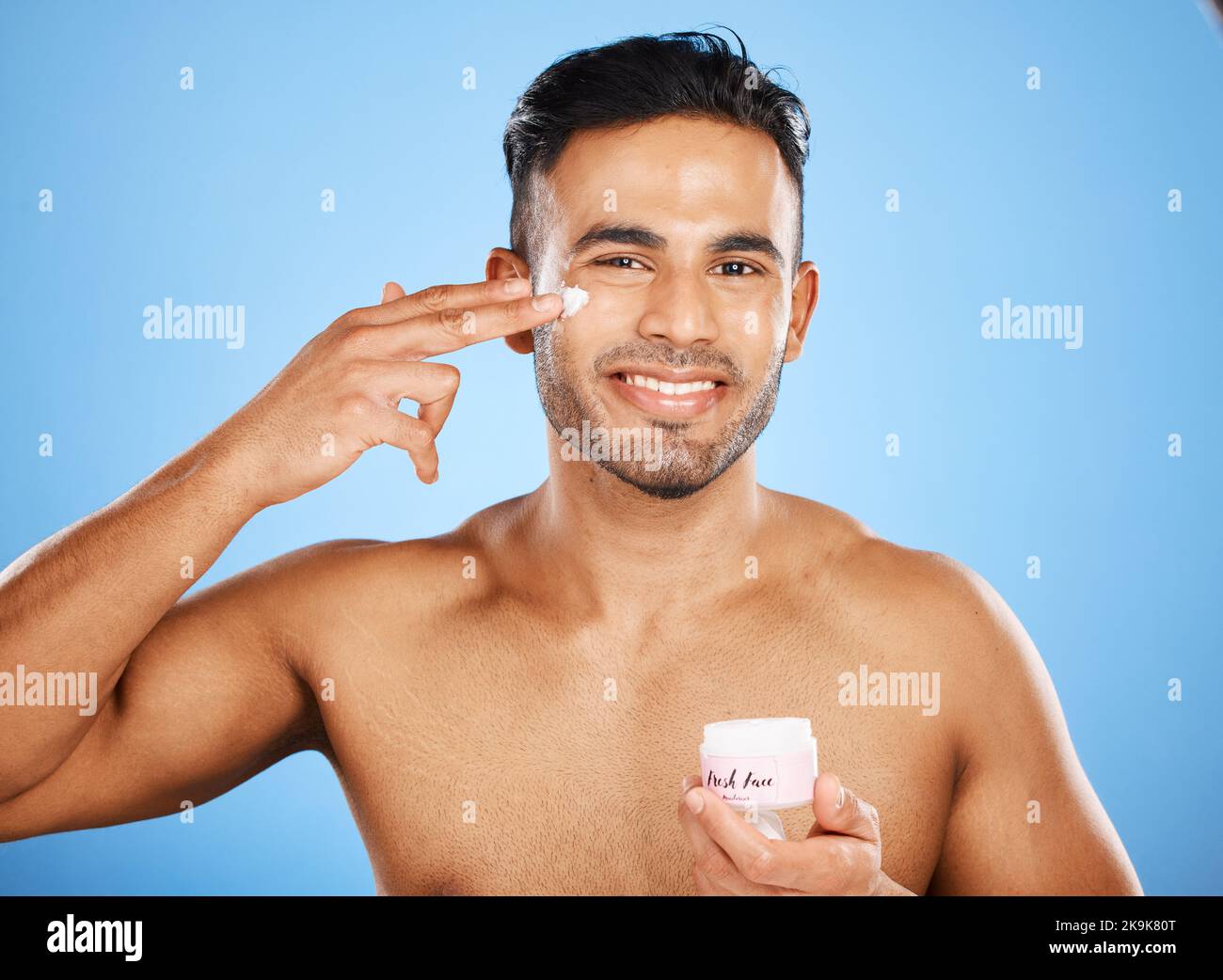 Beauty, skincare and man with cream on face for healthy skin on blue ...