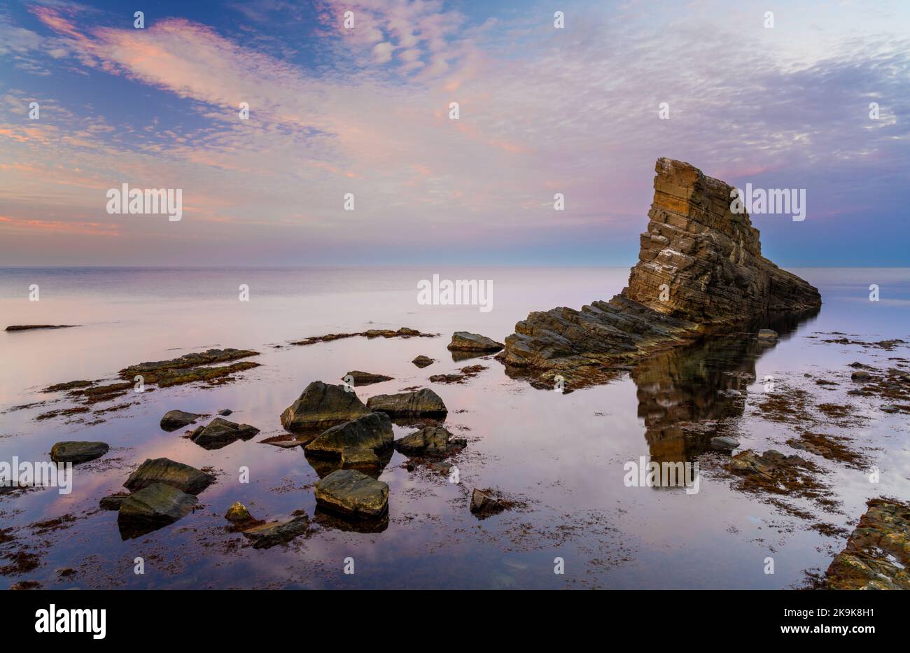 Colorful sunset over the Black Sea coast of Bulgaria with a sea stack ...